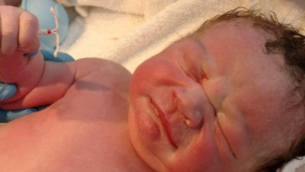 Baby holding IUD - Aleteia