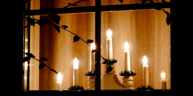 Why do people place candles in their windows at Christmastime?